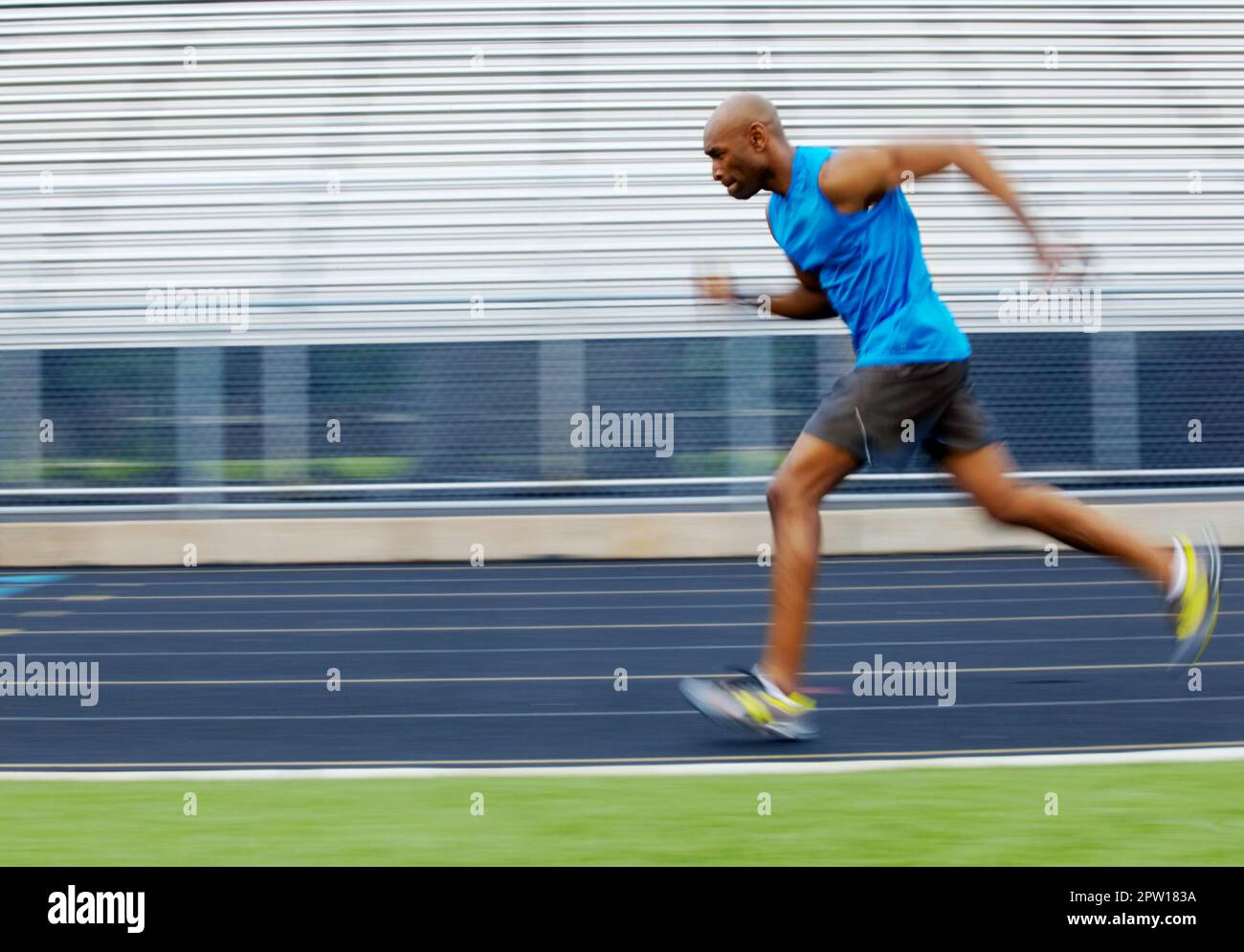 Running at full speed. Slightly blurred full length side view of a male ...