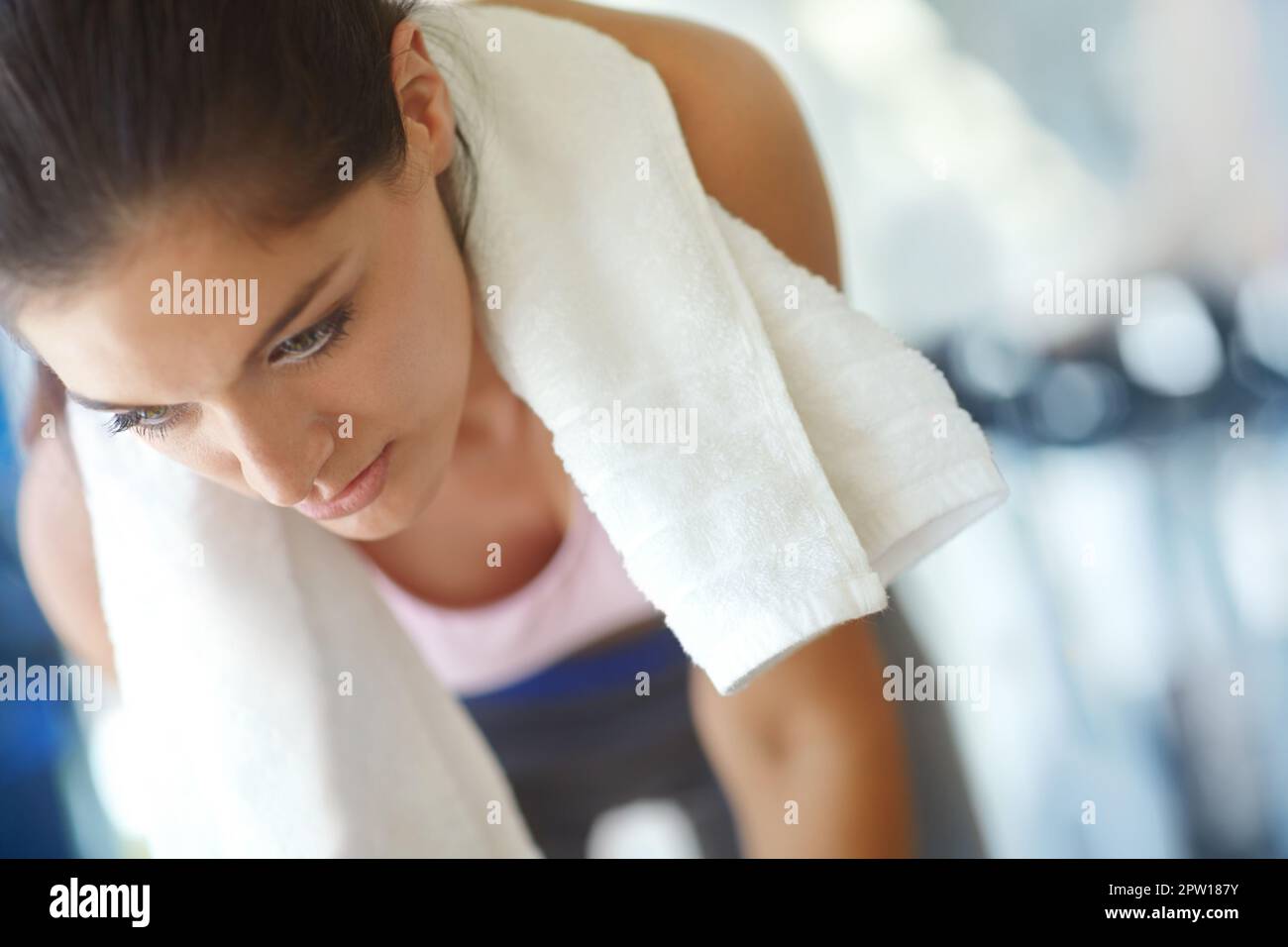 Keep pushing yourself. Closeup of a young woman exercising with a towel ...