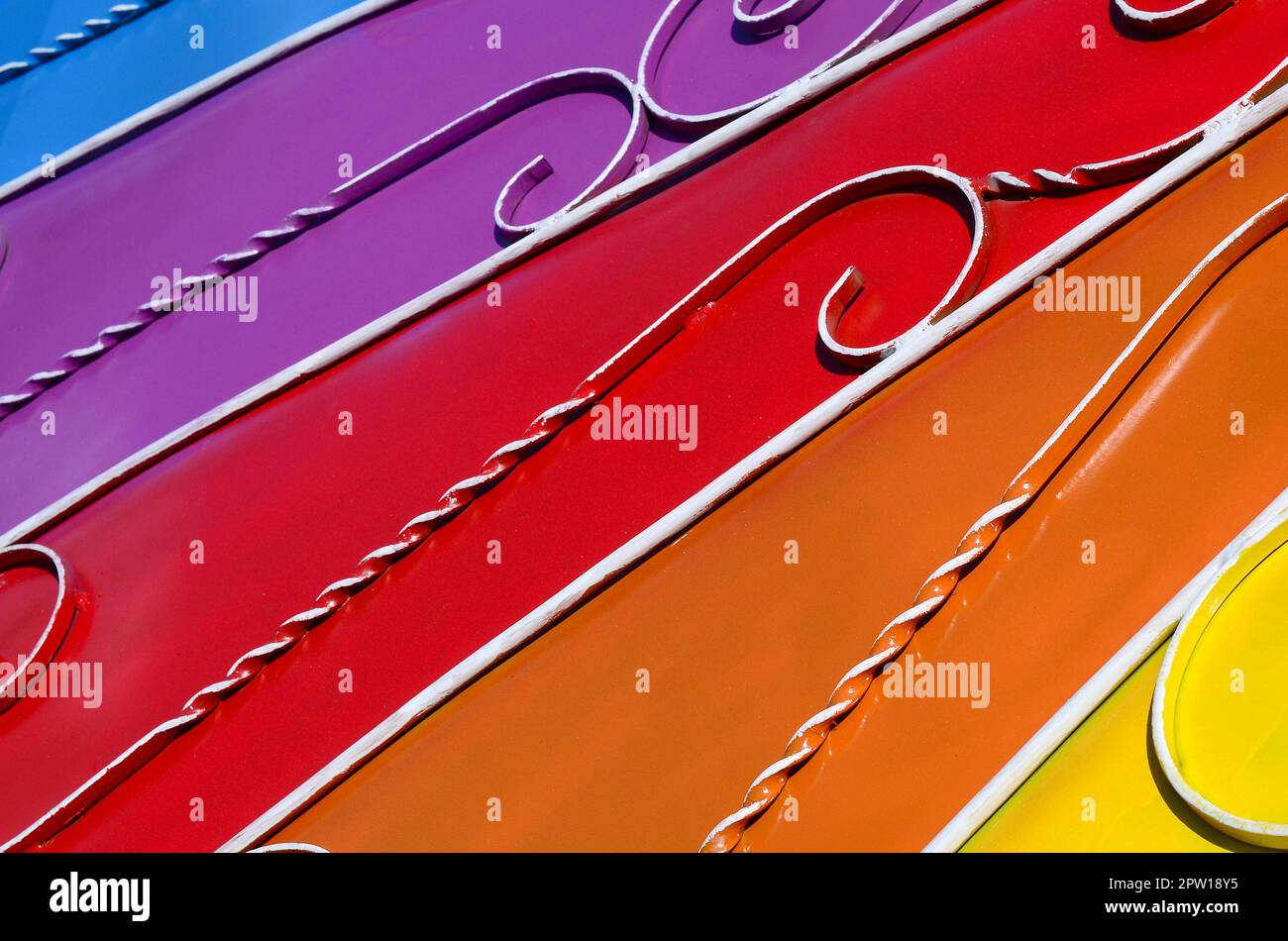 Metal texture of a piece of colored wall with a forged pattern. Rainbow ...