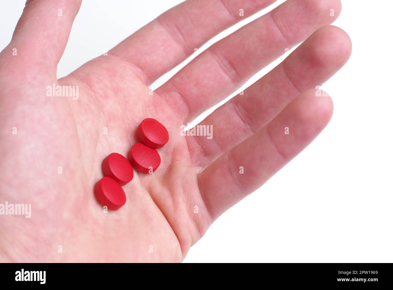 Medical treatment, prescription dose concept. Hand holding red pills on ...