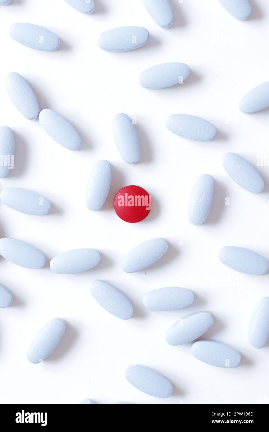 Medication, placebo concept. Single red pill shown prominently among ...