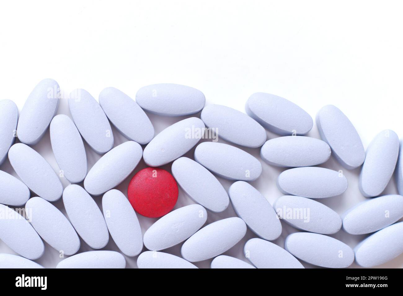 Medication, placebo concept. Single red pill shown prominently among ...
