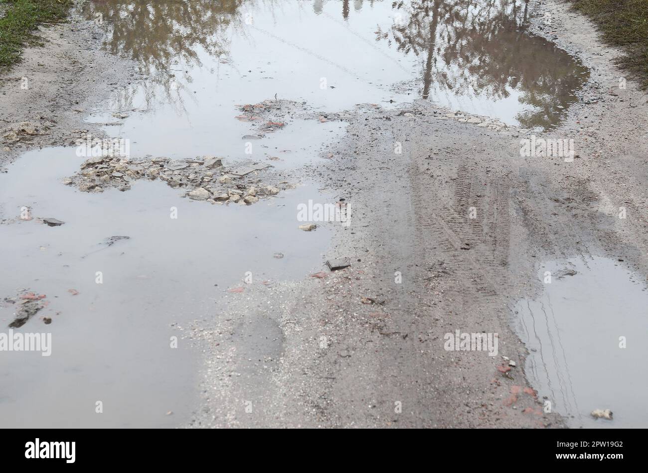 Photo of a fragment of a destroyed road with large puddles in rainy ...