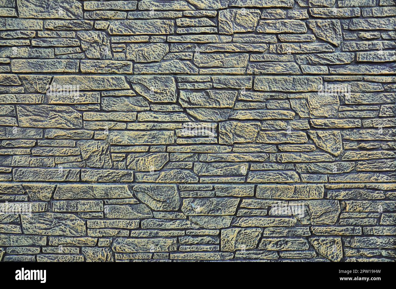 Fence texture of elongated colored stones in warm colors. Weathered ...