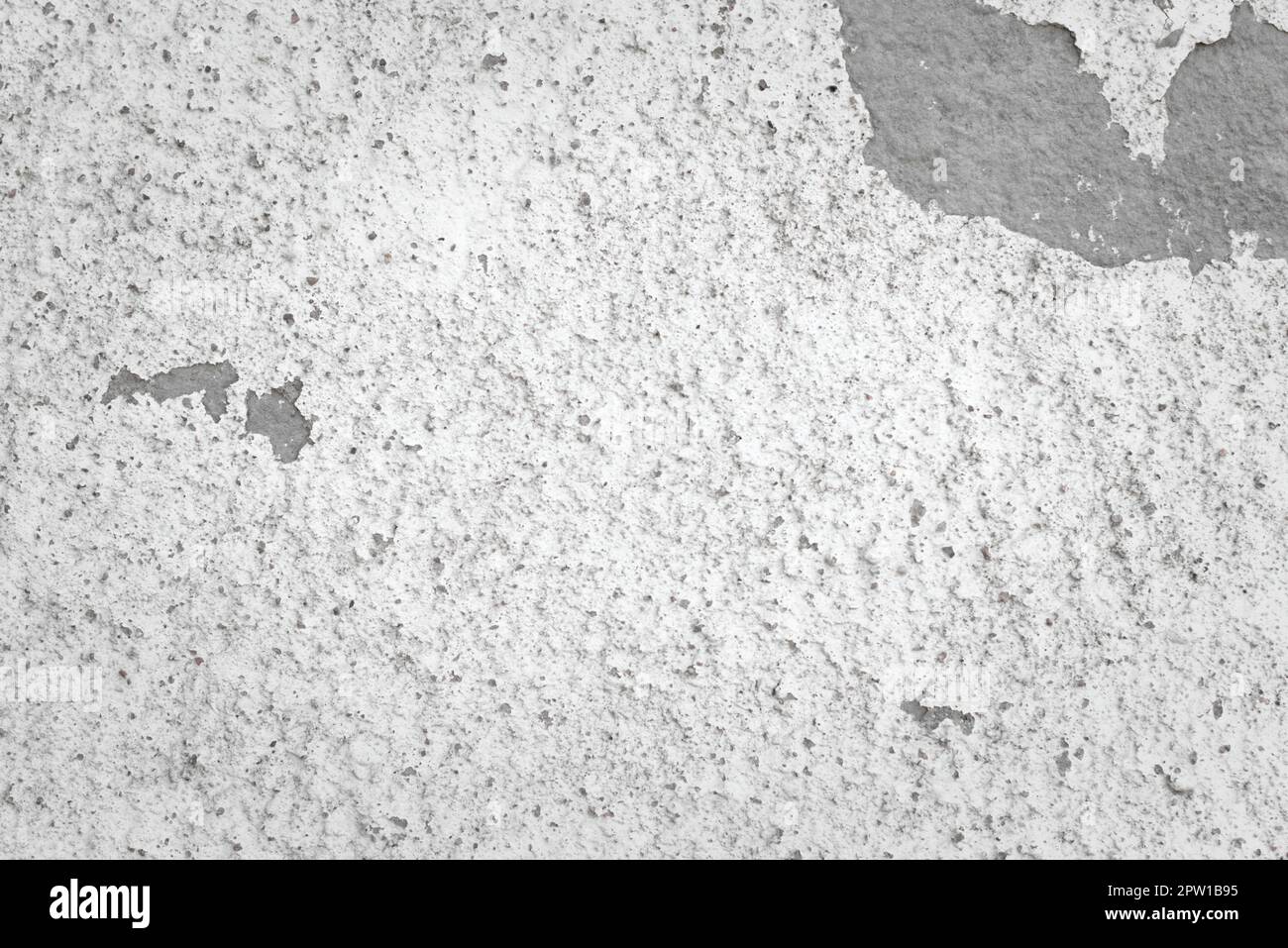 Weathered white wall. Peeling paint shows concrete underneath. Detail ...