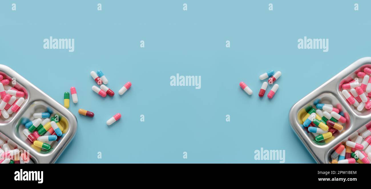 Above view of Colorful antibiotic capsule pills on tray and blue ...