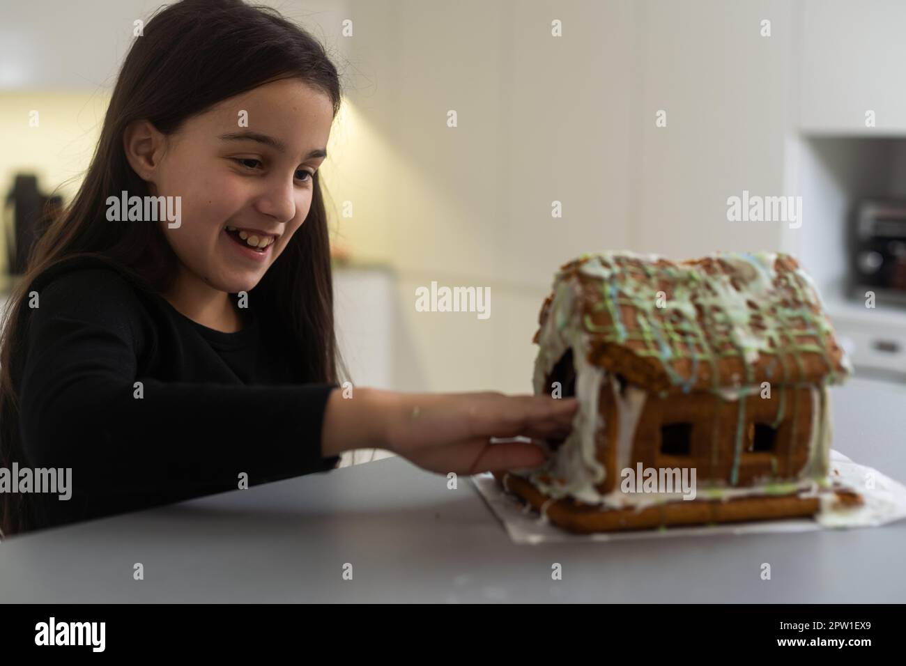 A teenage girl is eating a gingerbread house Stock Photo - Alamy