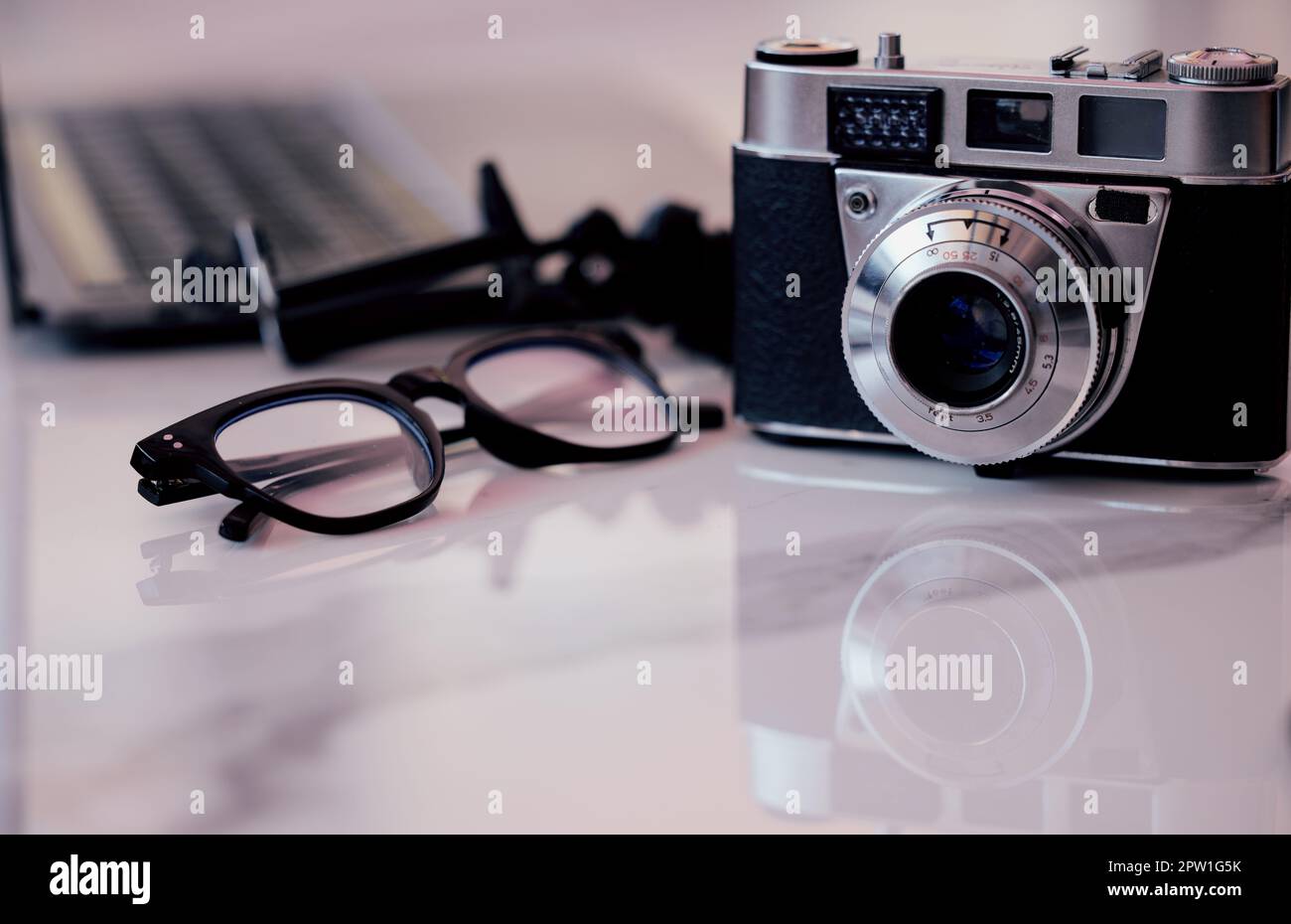 Closeup of a camera and glasses on a desk in an office. Blogger or ...