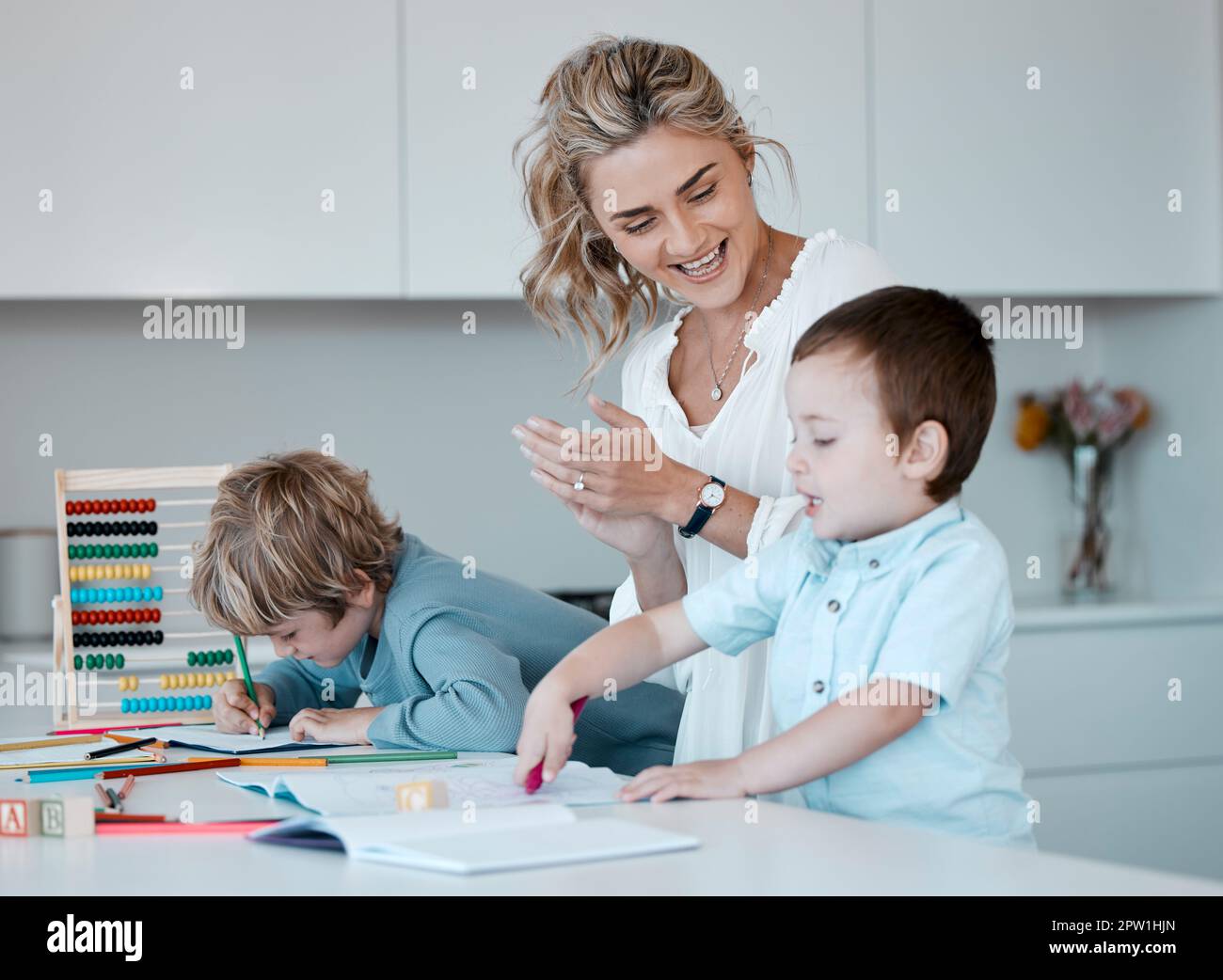 Single mother teaching little sons during homeschool class at home ...