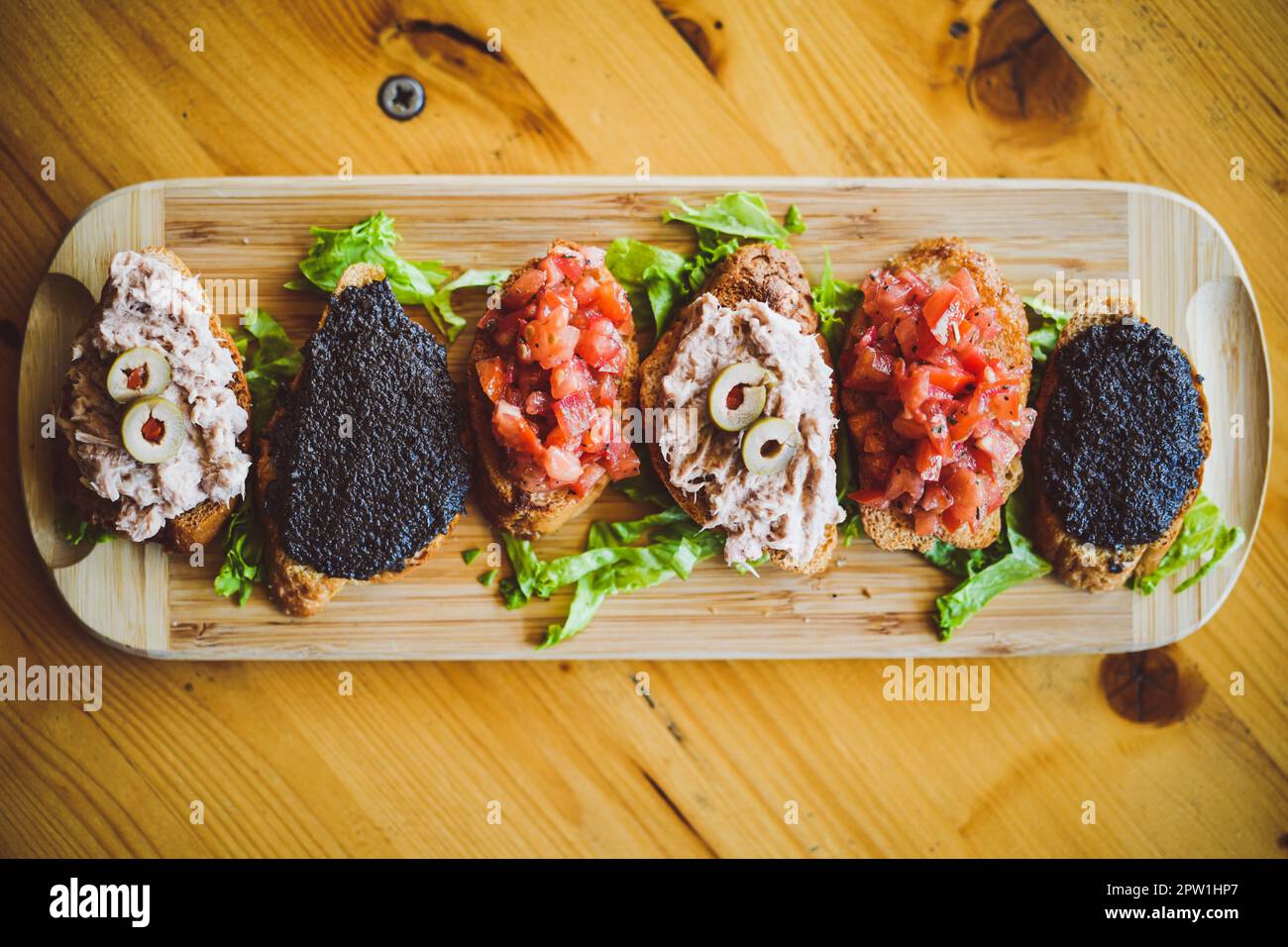 Selection of Spanish tapas served on a sliced baguette Stock Photo - Alamy