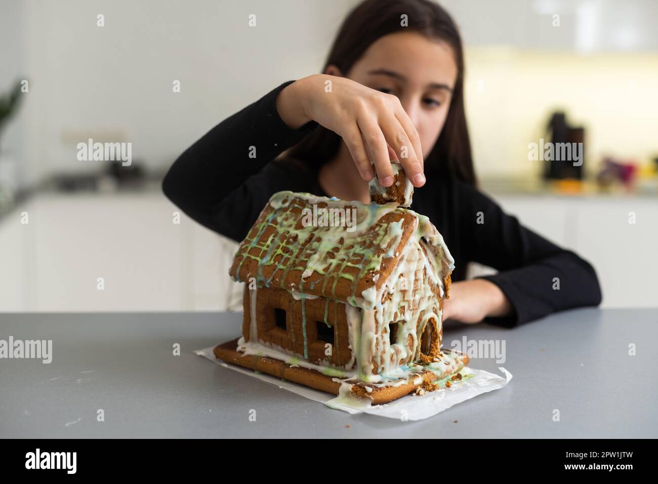 A teenage girl is eating a gingerbread house Stock Photo - Alamy