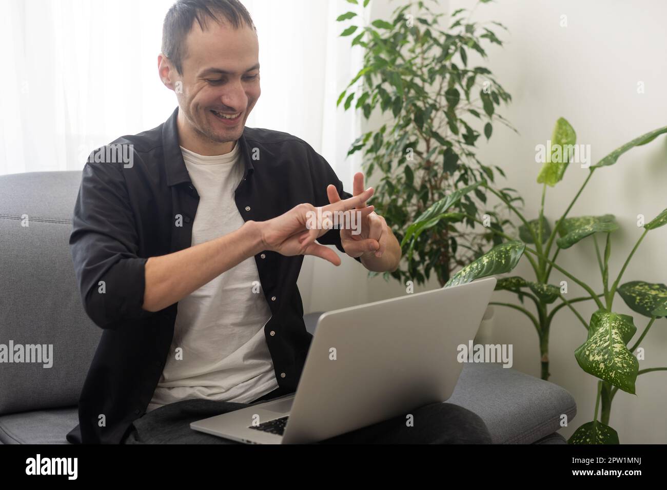 Happy smiling deaf young caucasian man uses sign language while video ...