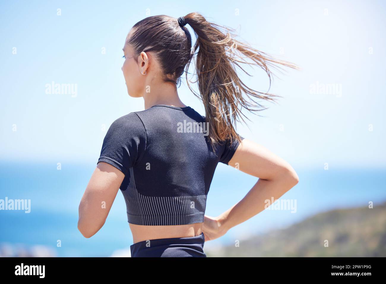 Rear view of Unknown fit active mixed race female running outside ...