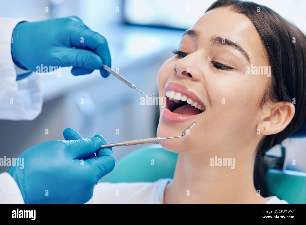 Giving her a million dollar smile. a young woman getting her teeth done ...