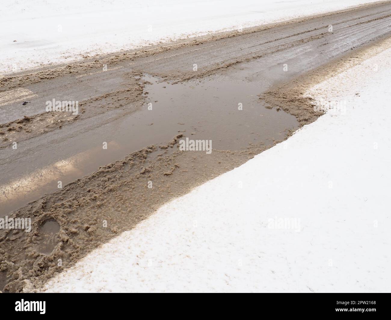 Snow, ice, slush and winter mud at a pedestrian crossing. The air ...