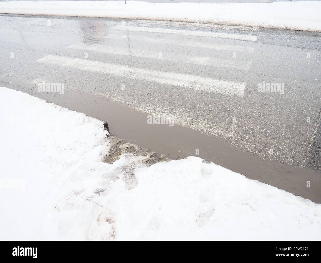 Snow, ice, slush and winter mud at a pedestrian crossing. The air ...