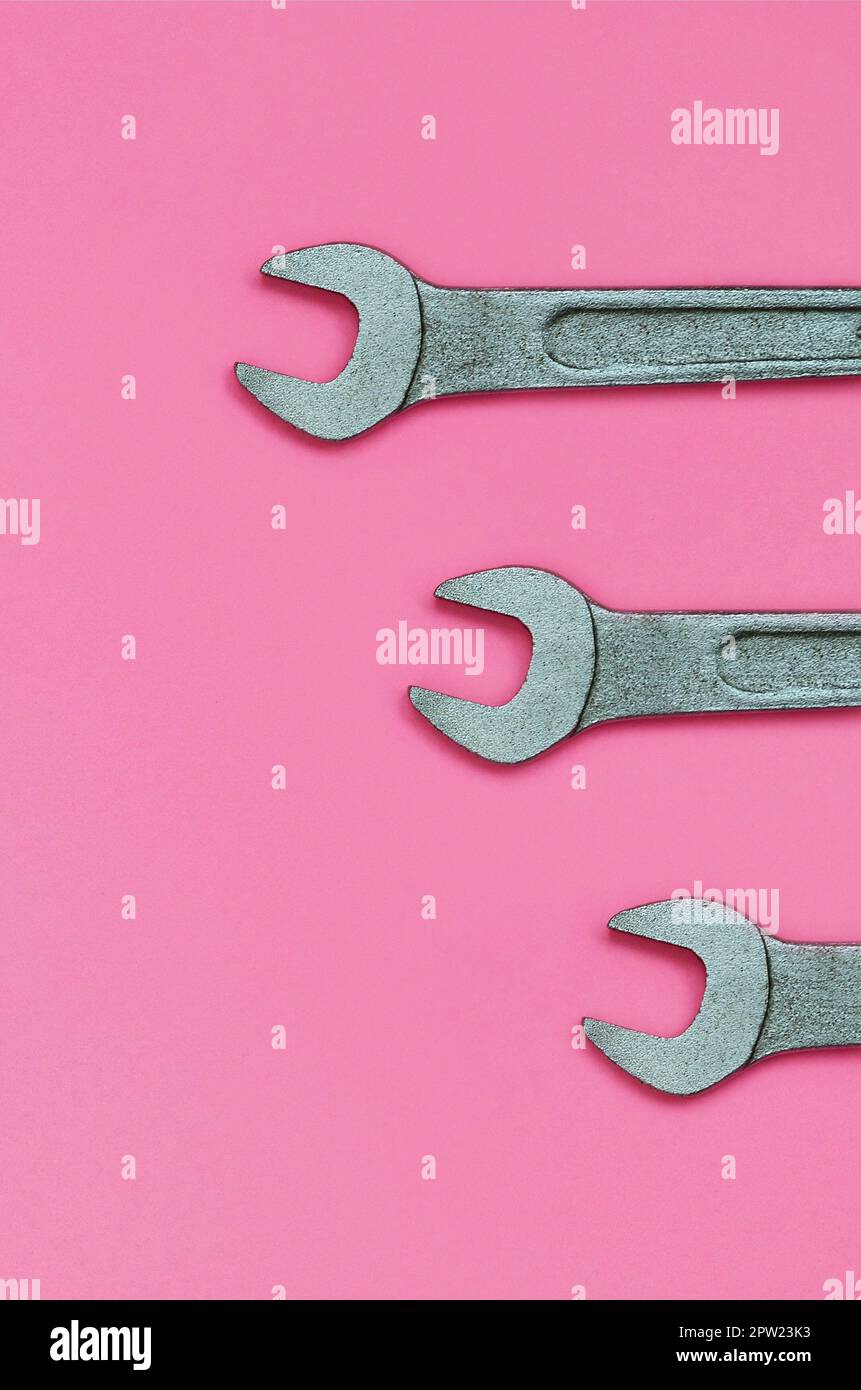 Three metallic spanners lie on texture background of fashion pastel ...