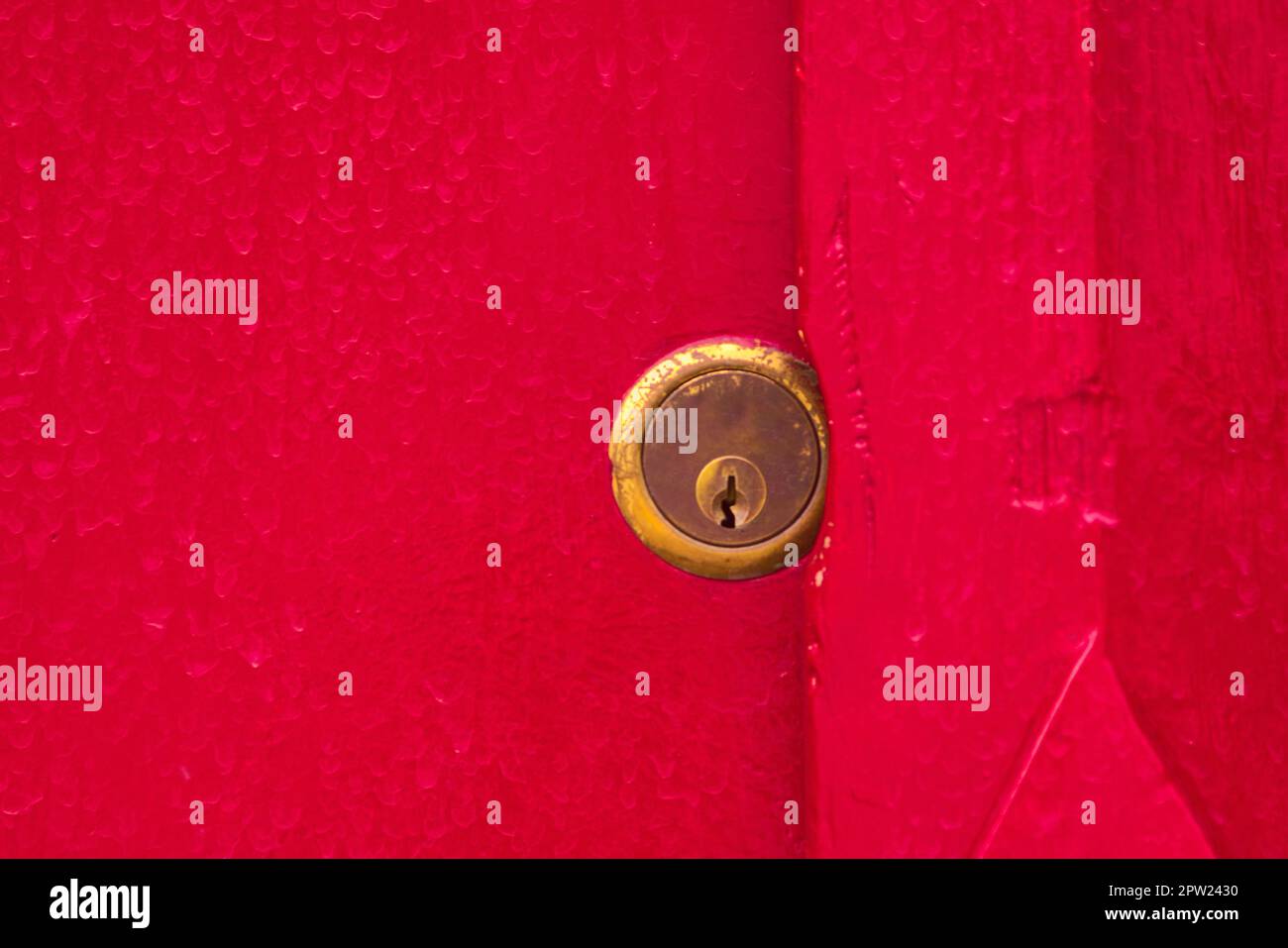 Brass lock on a blood red painted wooden door. Close up. Security ...