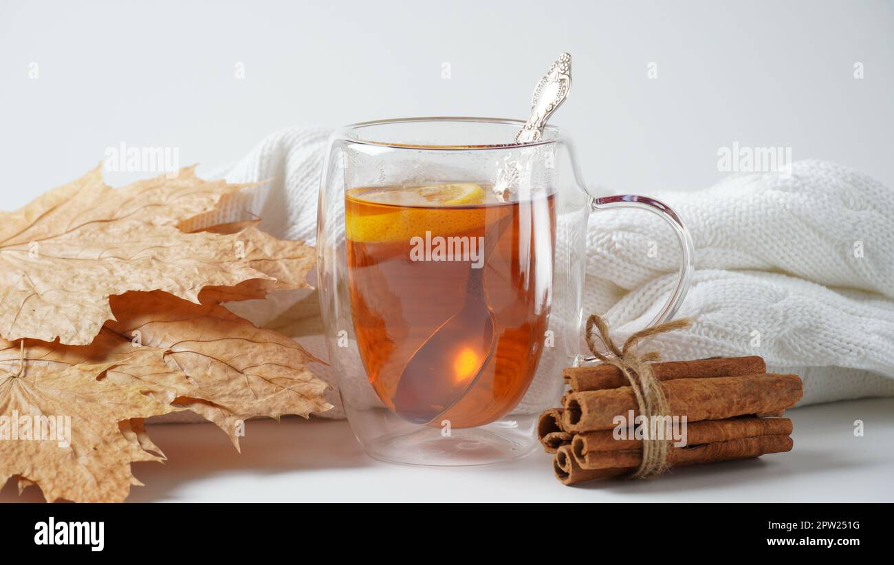 Autumn hot tea with cinnamon sticks and lemon in transparent cup Stock ...
