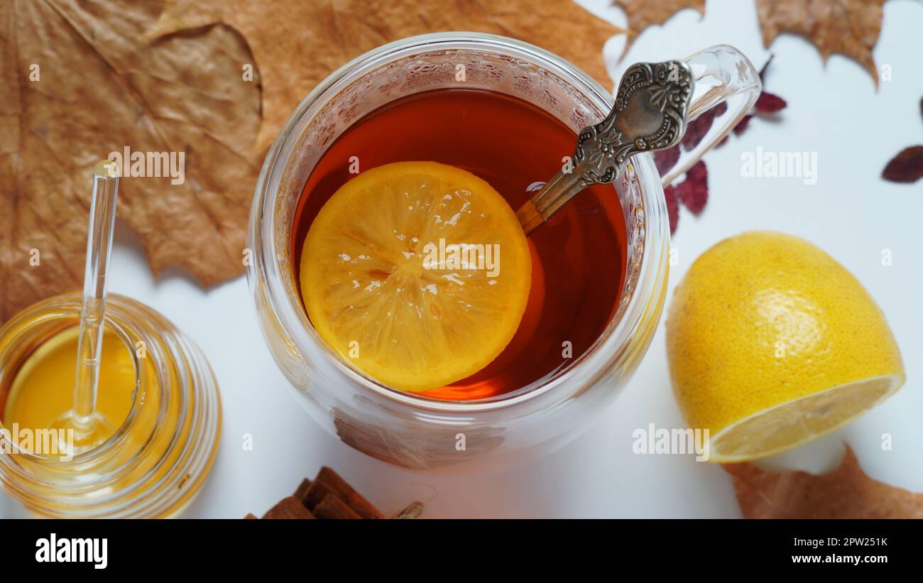 Autumn hot tea with cinnamon sticks and lemon in transparent cup Stock ...
