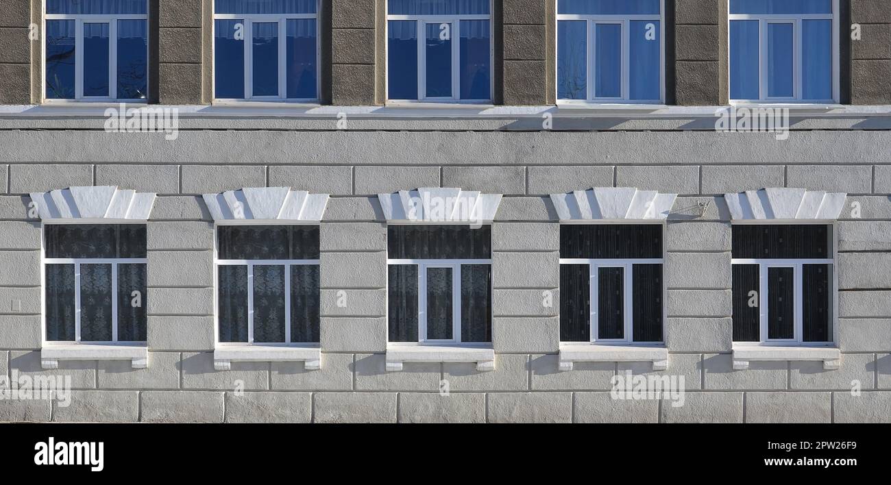 Texture of a glazed modern windows of a grey concrete building. Close ...