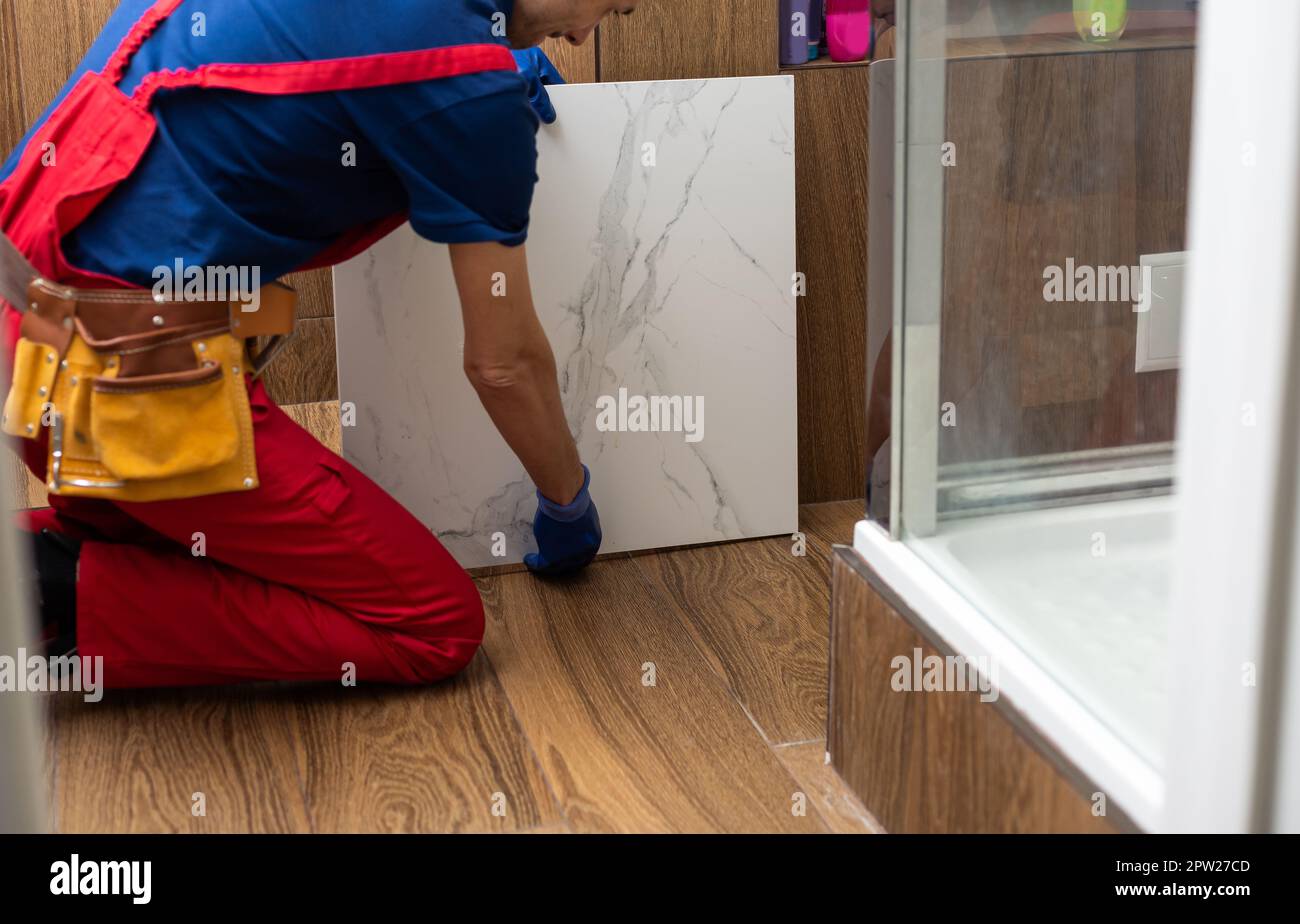 Industrial tiler builder worker installing floor tile at repair ...
