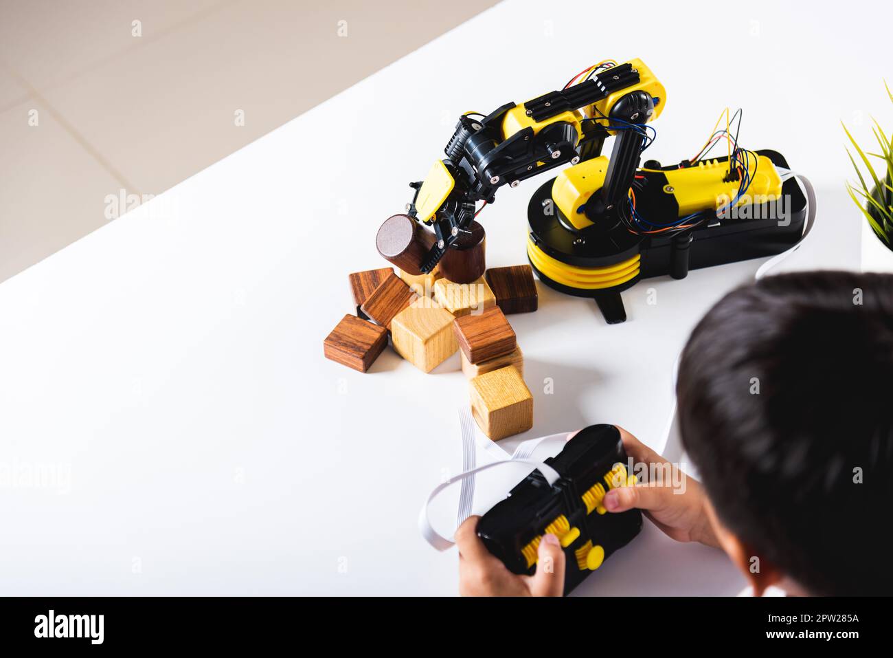 Happy Asian little kid boy using remote control playing robotic machine ...