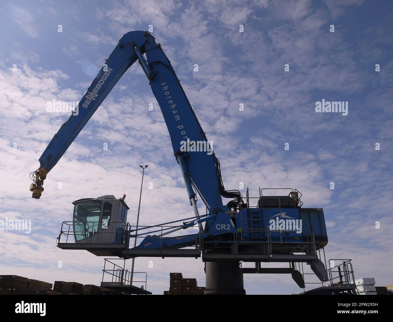 A Sennebogen crane towering above piles of imported timber at Shoreham ...