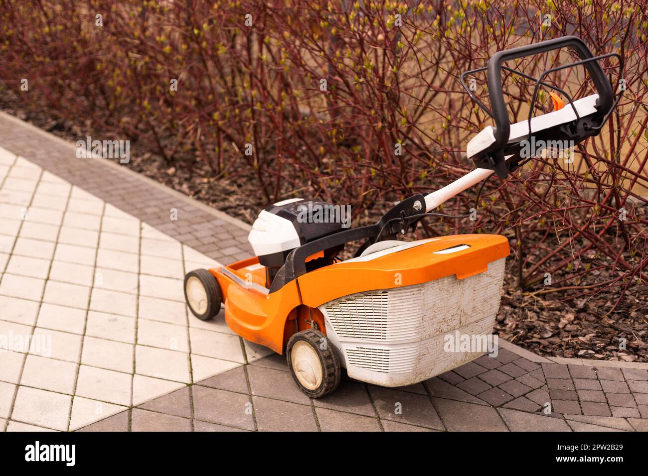 Automatic lawnmower in modern garden Stock Photo - Alamy