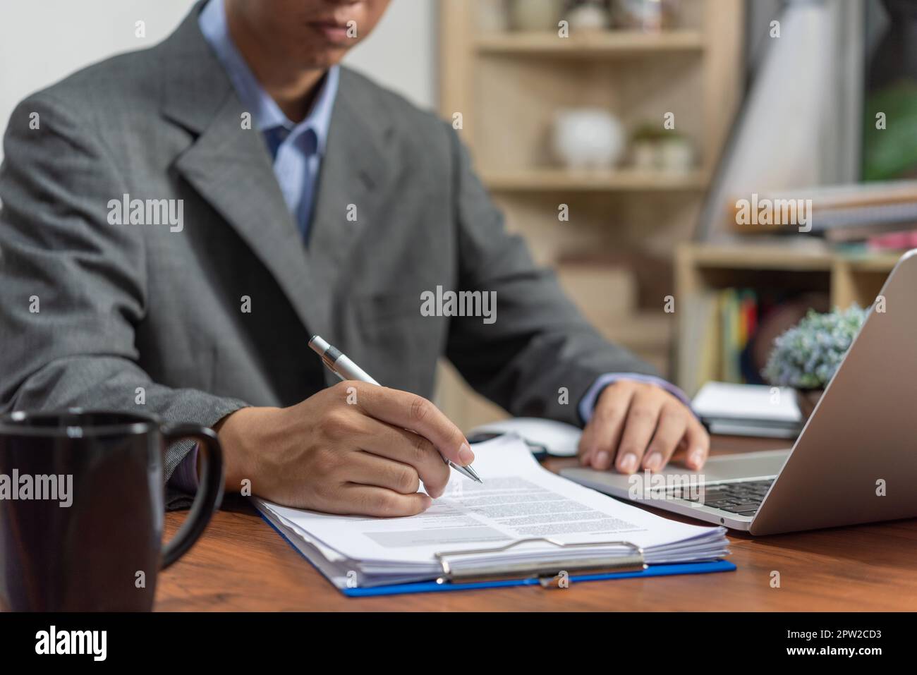 businessman signs documents with a pen making the signature on desk ...