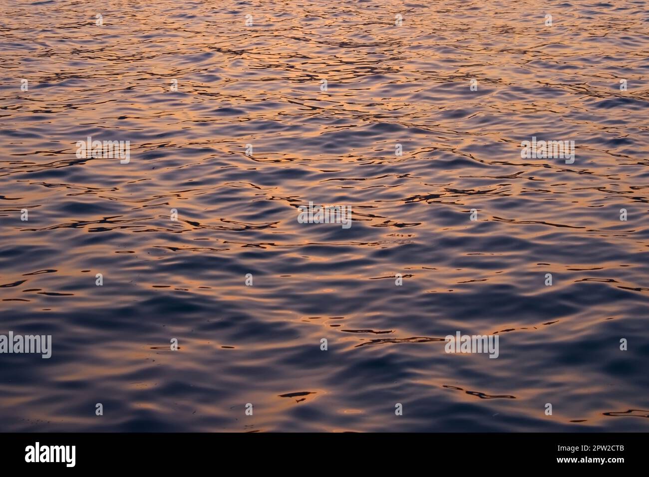 Dark waters reflecting the ochre colors of a sunset sky Stock Photo - Alamy