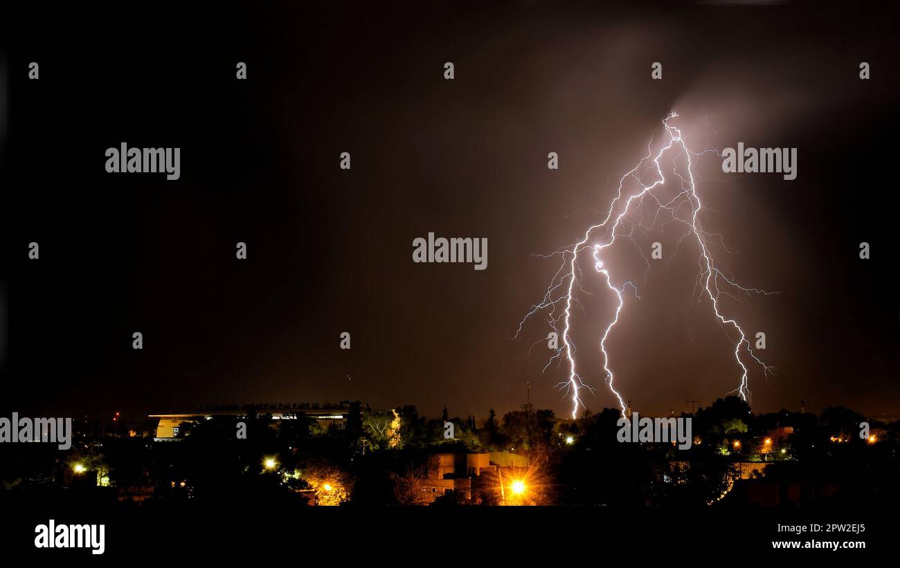Lightning strikes at night during a severe thunderstorm over the city ...