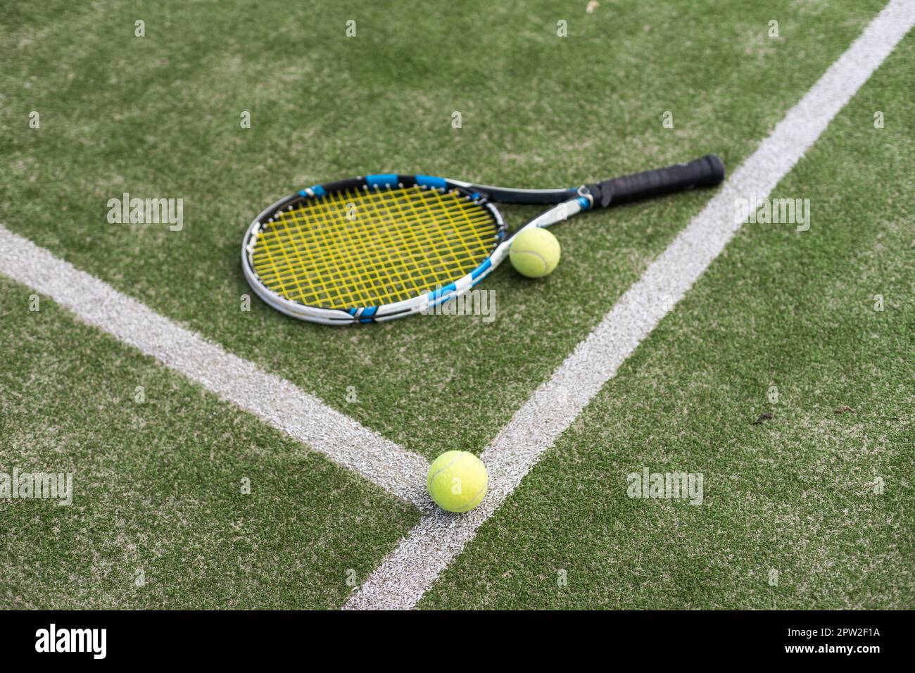 Close up of tennis rackets and tennis balls lying on tennis court ...