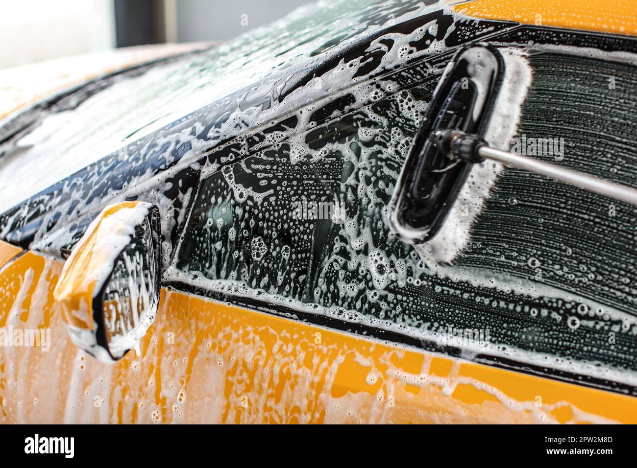 Yellow car side window washed in self service carwash. rush leaves ...