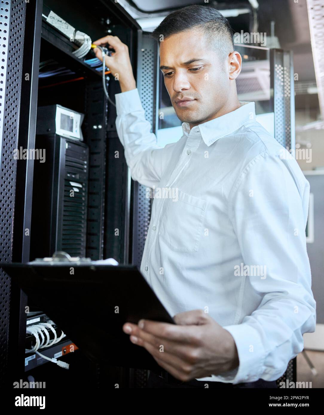 Server room, database and IT support with a man programmer working on ...