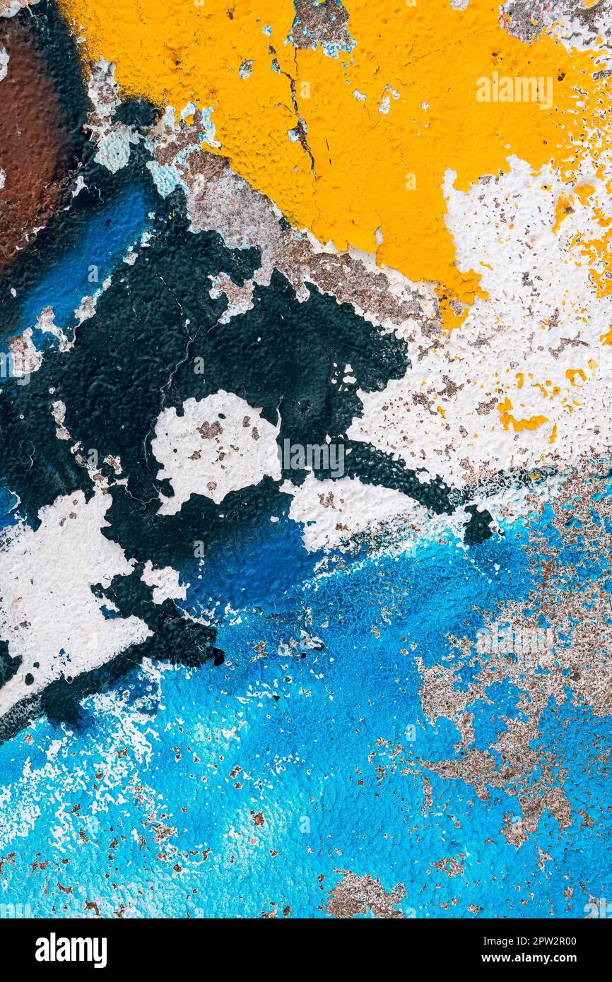 Peeling paint on the wall. Concrete wall with old cracked flaking paint. Weathered rough painted ...