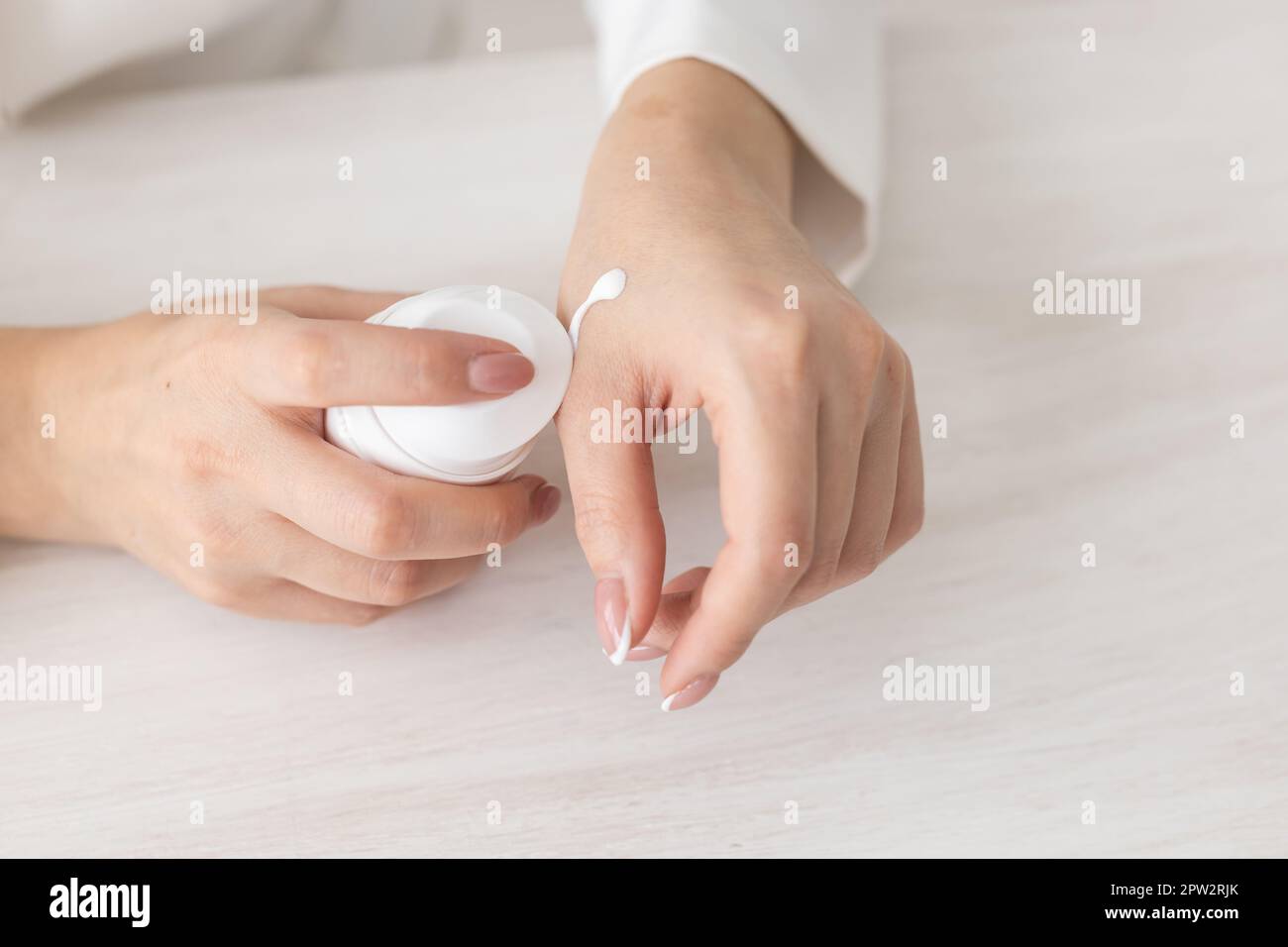 Female hands with cream. Woman applies cream on her hands. Palms down ...