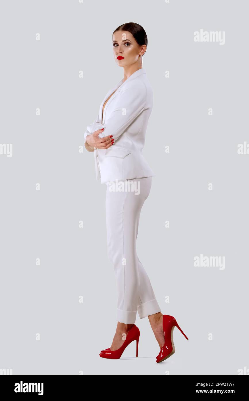Strict lady in white pantsuit with crossed hands in profile Stock Photo ...