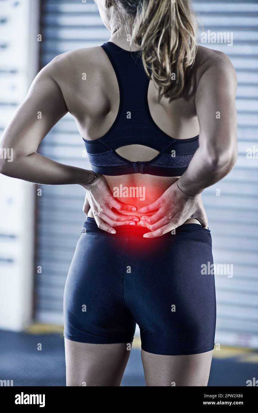 Prevent back pain...Rearview shot of a young woman holding her injured ...