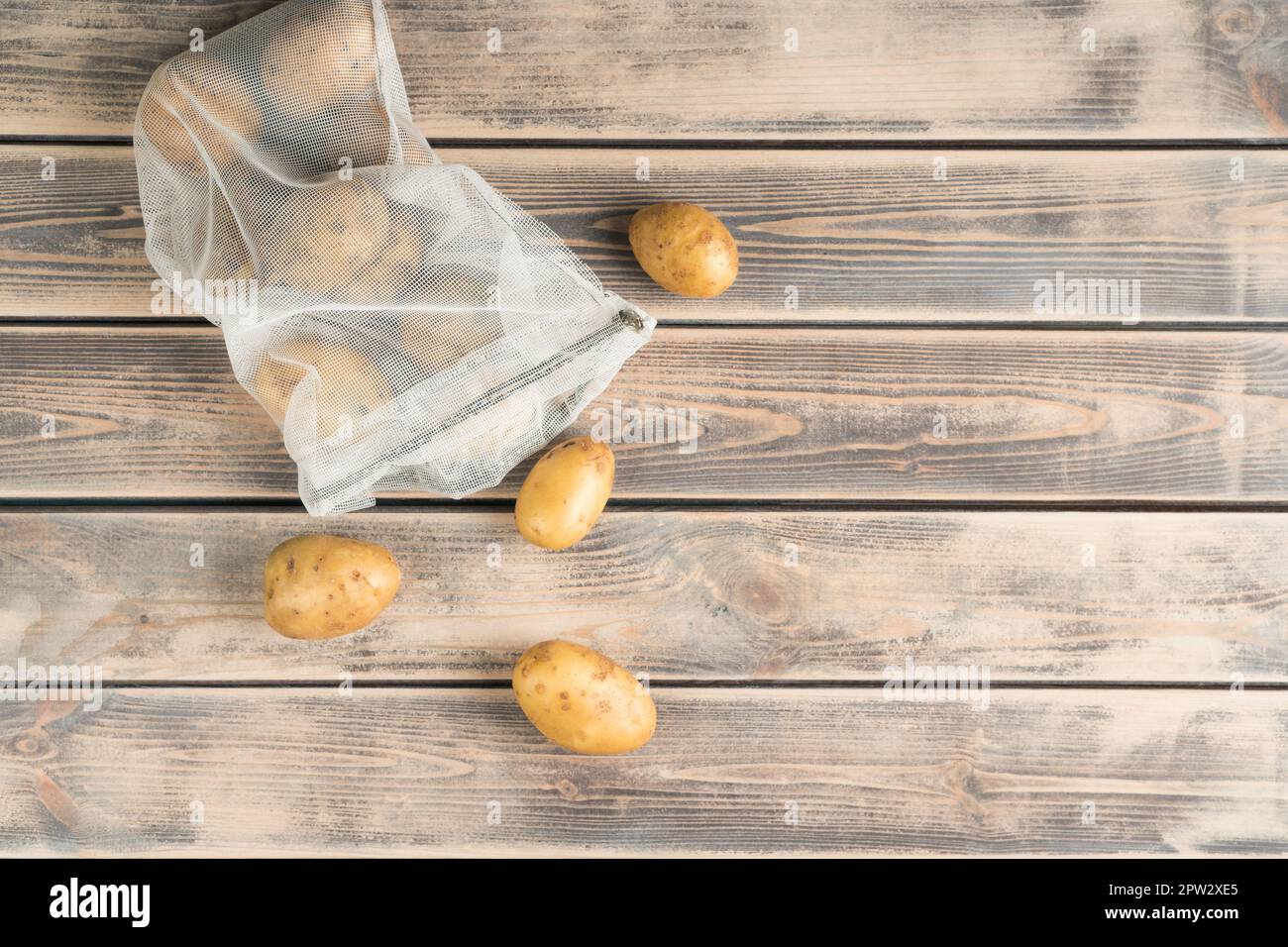 Composition of raw fresh potato in transparent packet on wooden ...