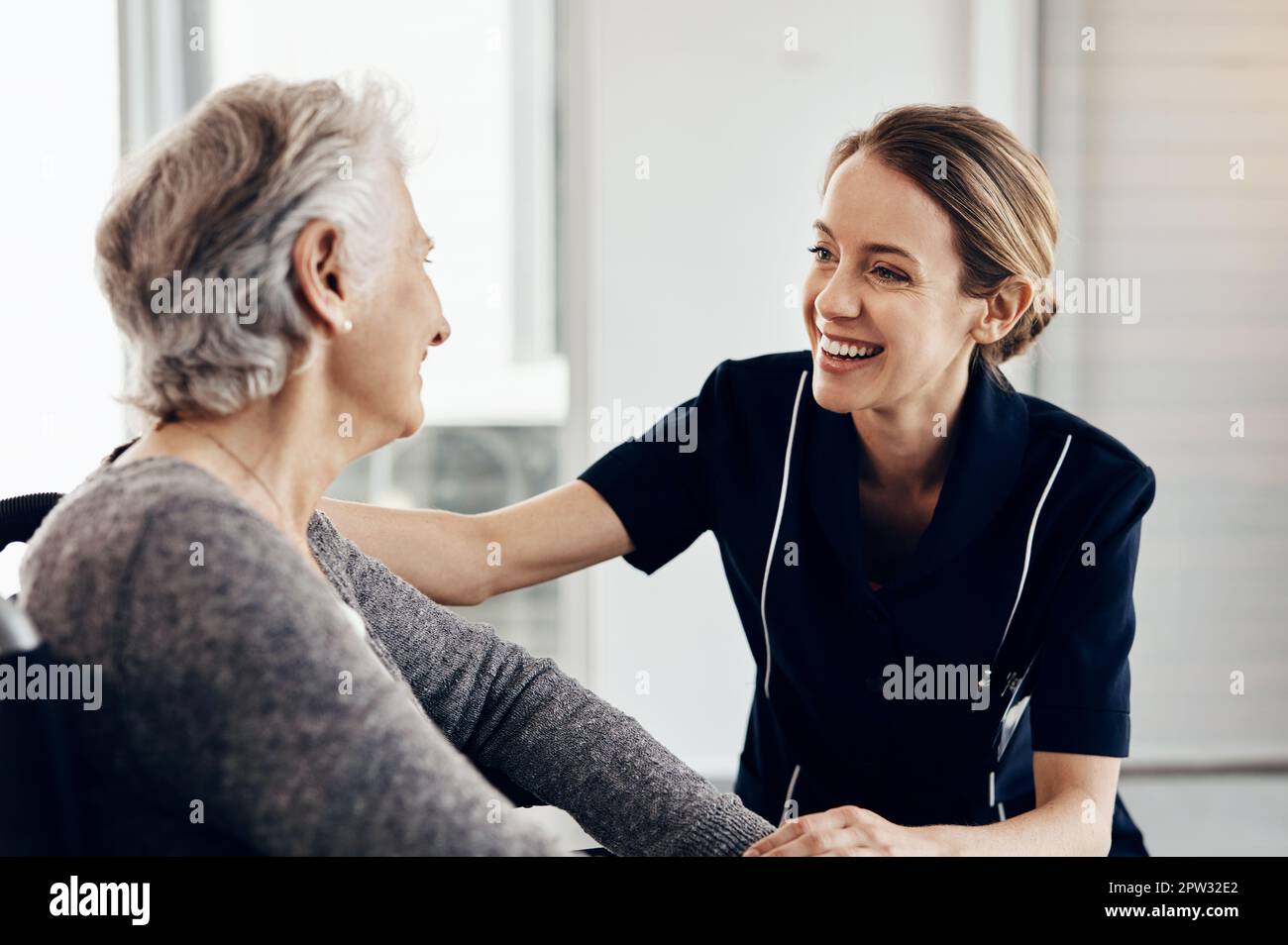 The simple act of caring is heroic. a female nurse caring for a senior ...