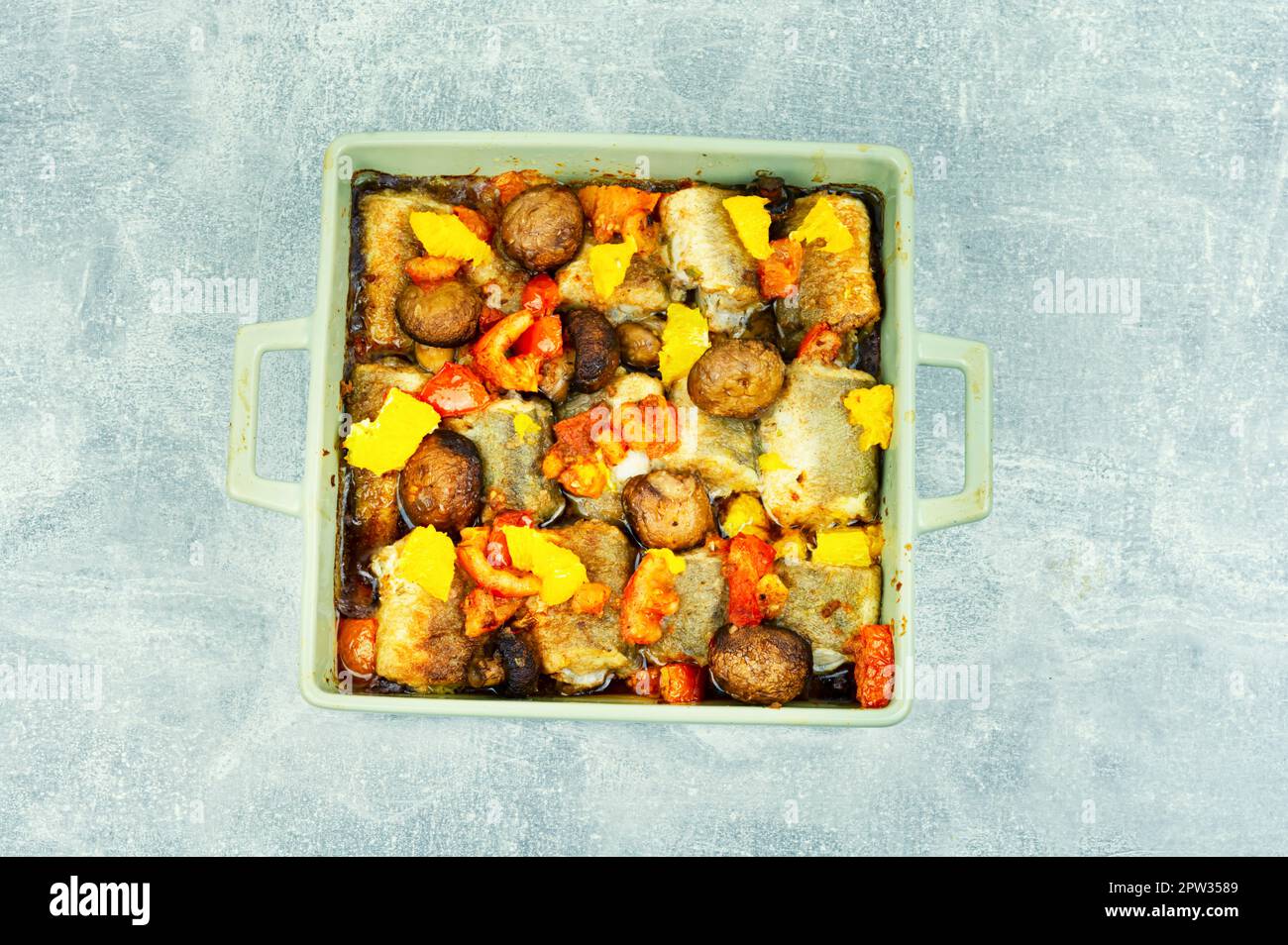 Diet fish hake cooked with mushrooms, orange and tomatoes Stock Photo ...