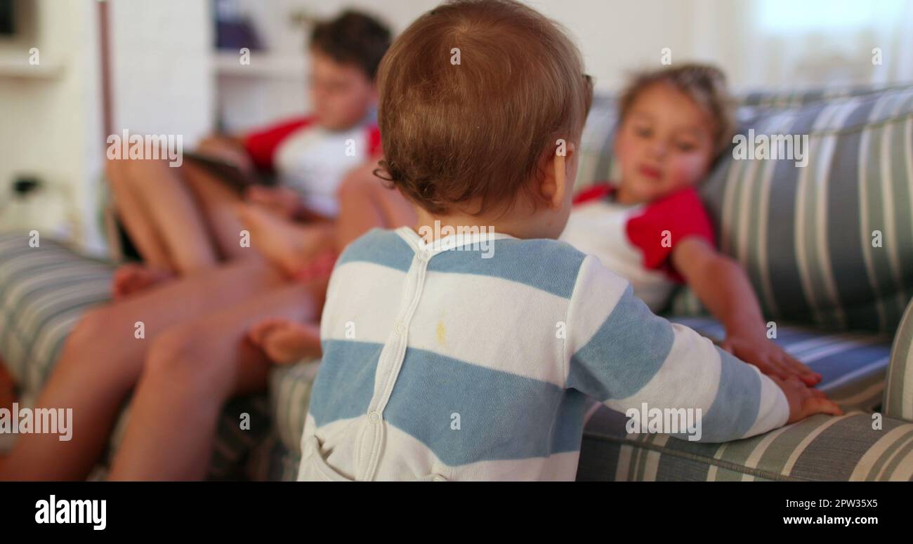 Baby infant interaction with siblings at home, candid and real. Toddler ...