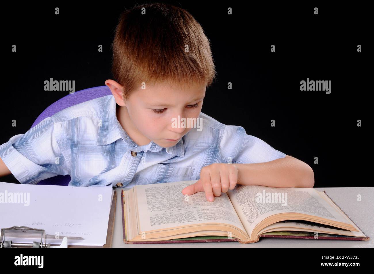 Young boy hard at work studying his books Stock Photo - Alamy