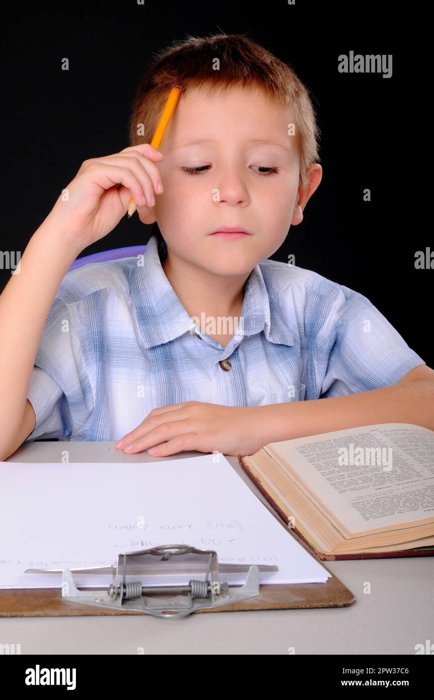 Young boy hard at work studying his books Stock Photo - Alamy