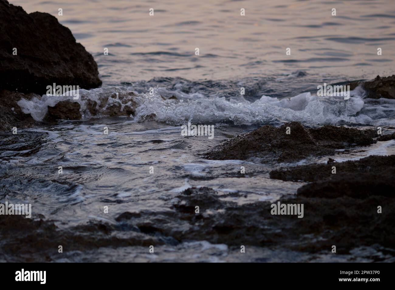 Close up wave in the sunset. Sea waves crashing into rocks. Storm at ...