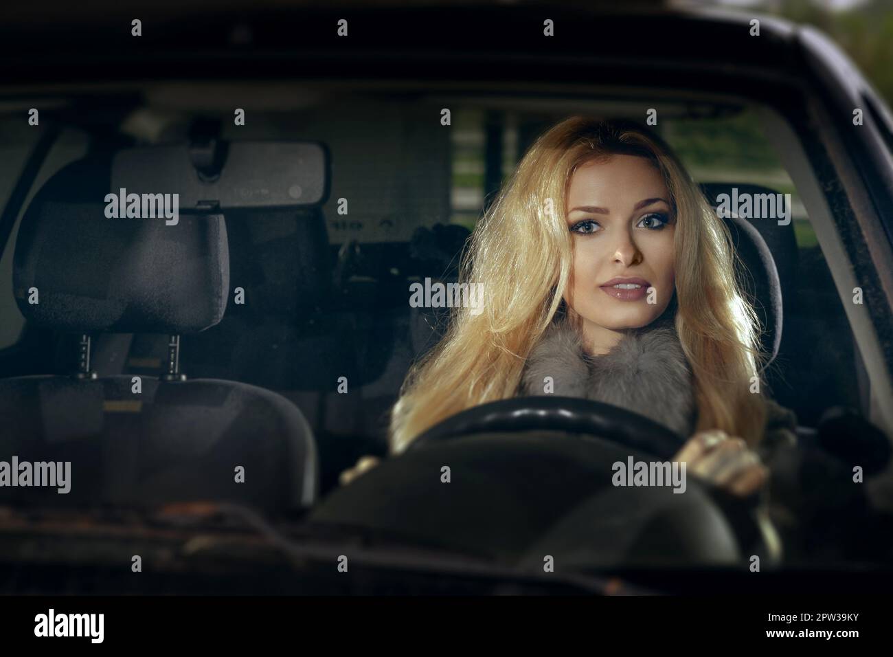 City portrait of pretty blonde driver inside the car. Night scene. Lady ...