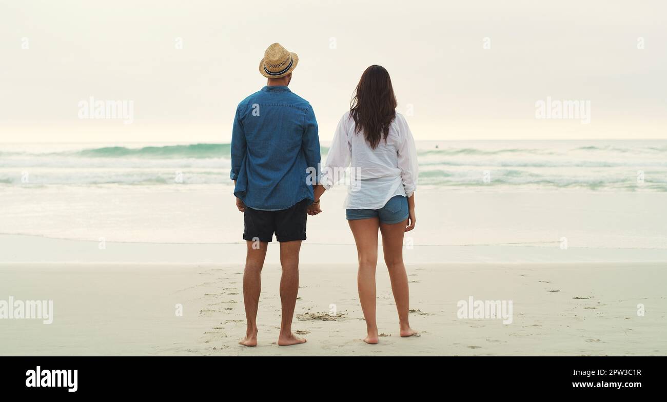 The perfect beach date. Full length rearview shot of an affectionate ...