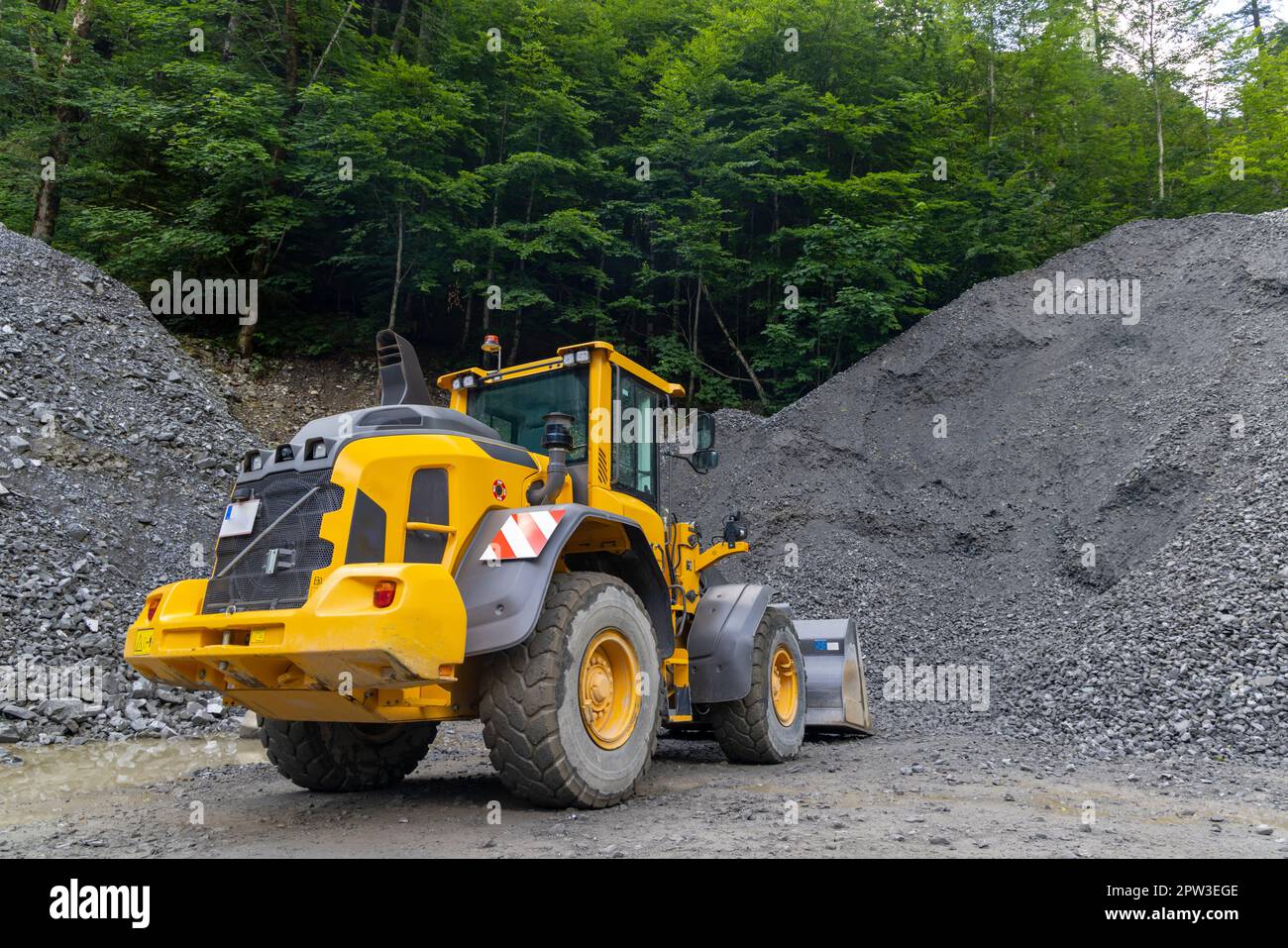 yellow digger with grey gravel for construction of the road Stock Photo ...