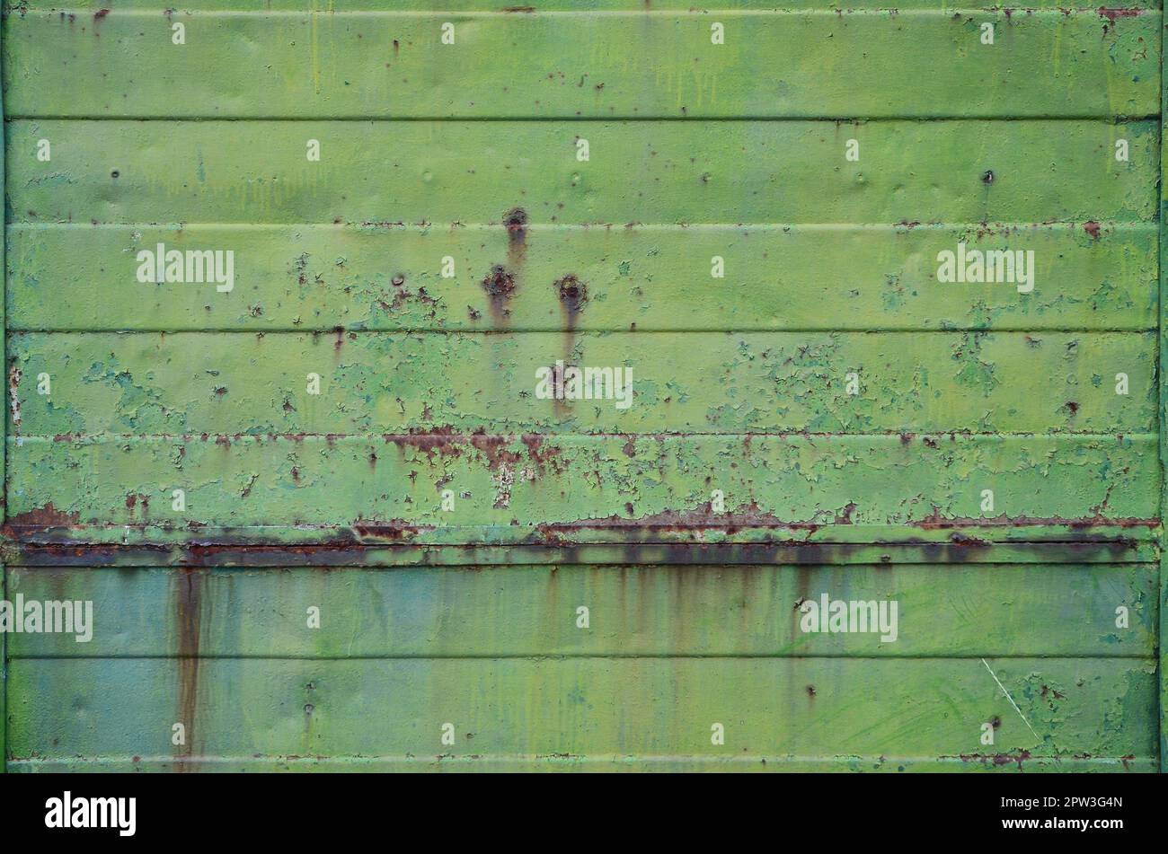 Texture of an old green metal wall with significant damage from ...